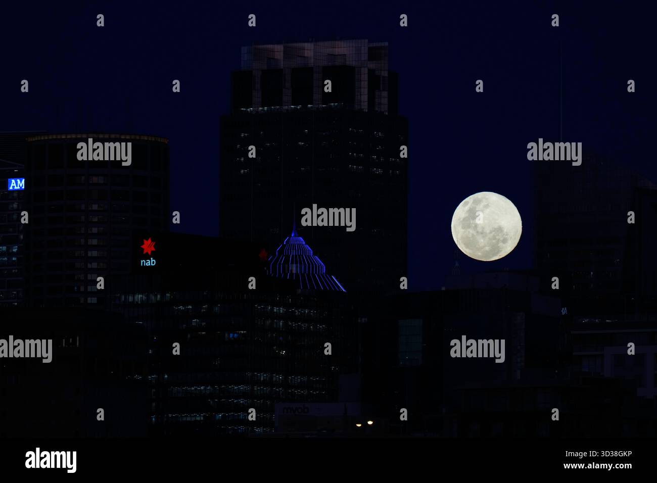 The moon rises between buildings in Sydney, Australia, Wednesday, Nov ...