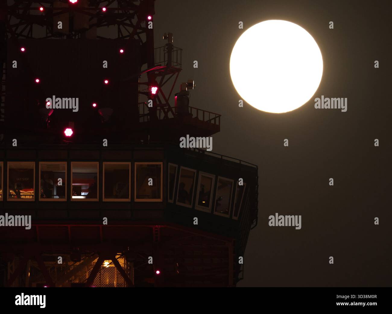 The photo shows the largest full moon of the year, a "supermoon," hanging over the Sapporo TV ...