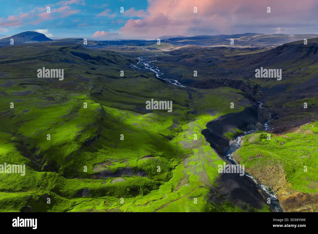 Aerial river snakes through moss valleys and volcanic fields in Iceland ...