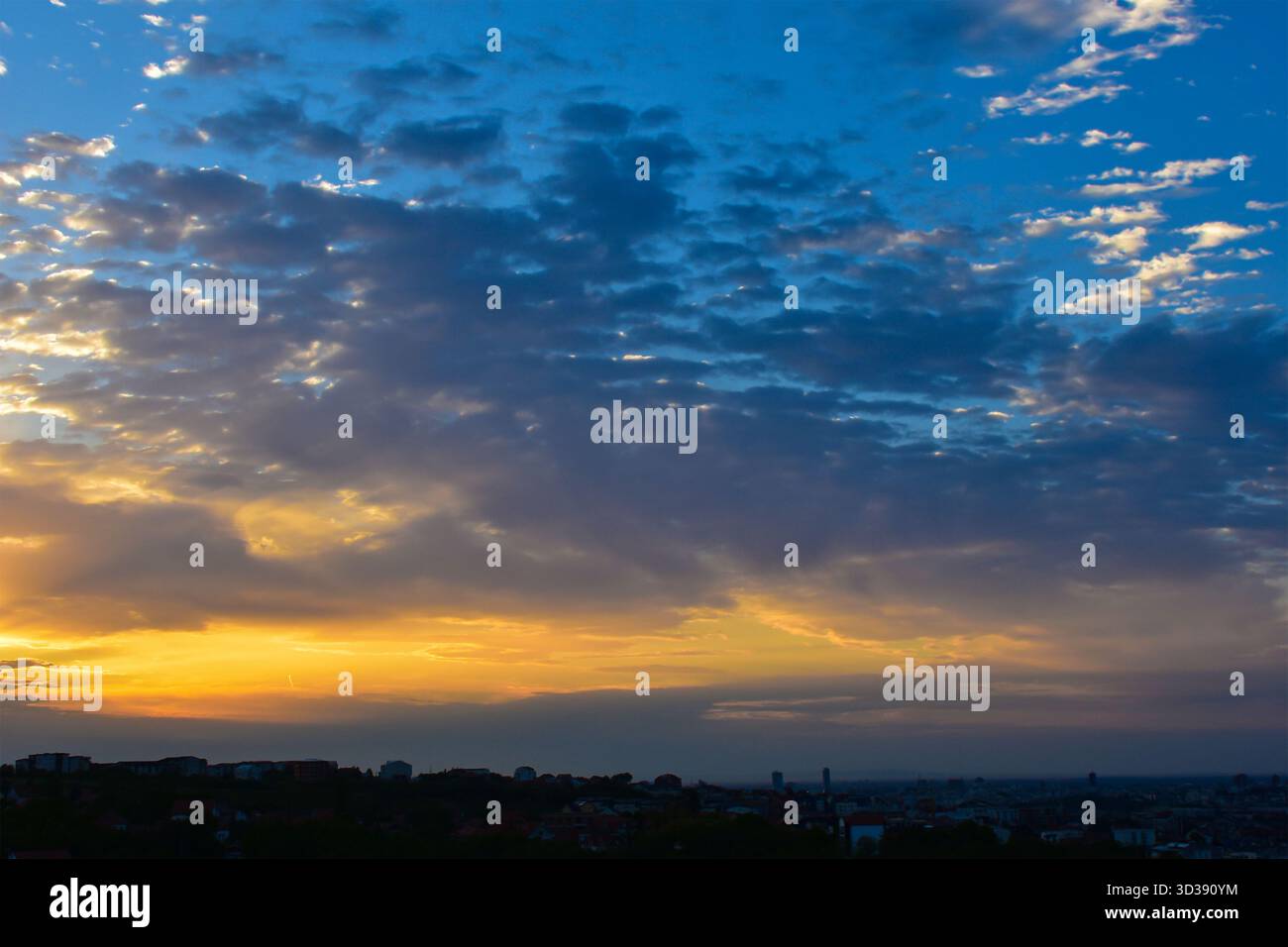 City skyline under a glowing sunset sky, with soft golden light ...