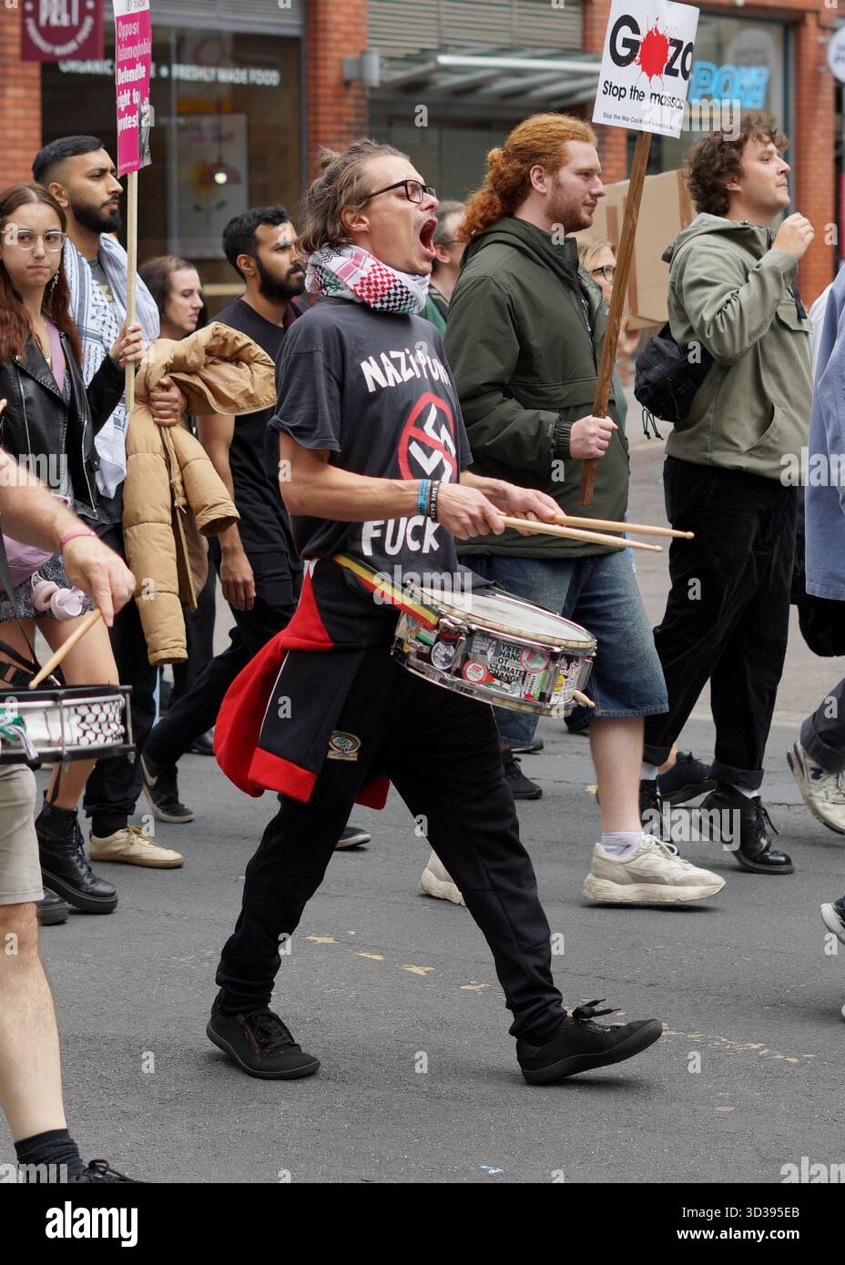 Protest drummer weaing an anti-nazi t-shirt marches through Manchester ...