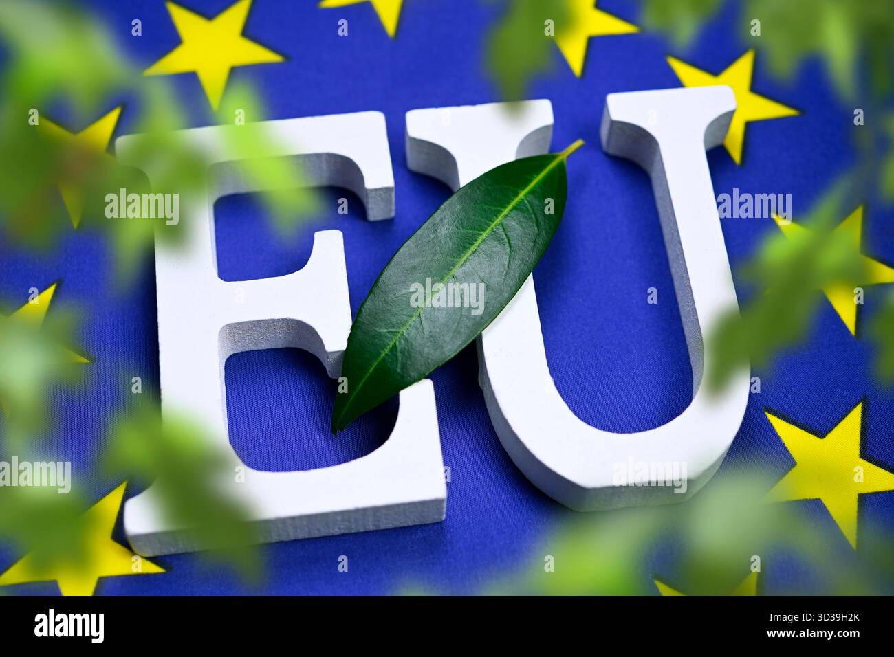 FOTOMONTAGE, EU-Schriftzug mit Blatt auf EU-Fahne, Symbolfoto für die ...