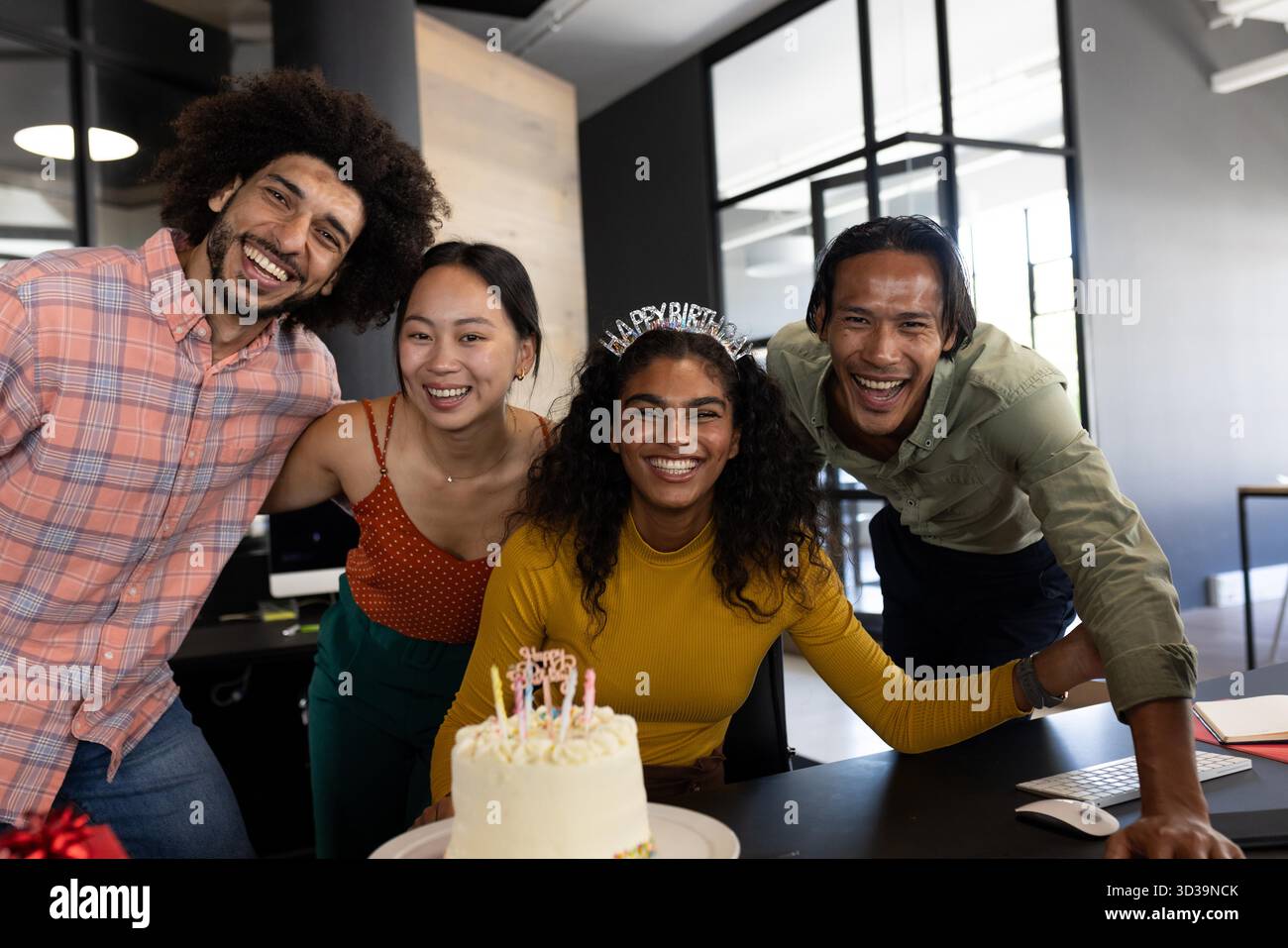 In office, colleagues gathering around cake, celebrating birthday with ...