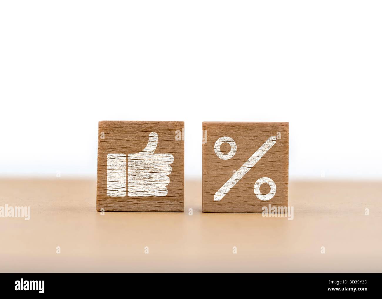 Two wooden blocks sit on a smooth surface, one featuring a thumbs up ...