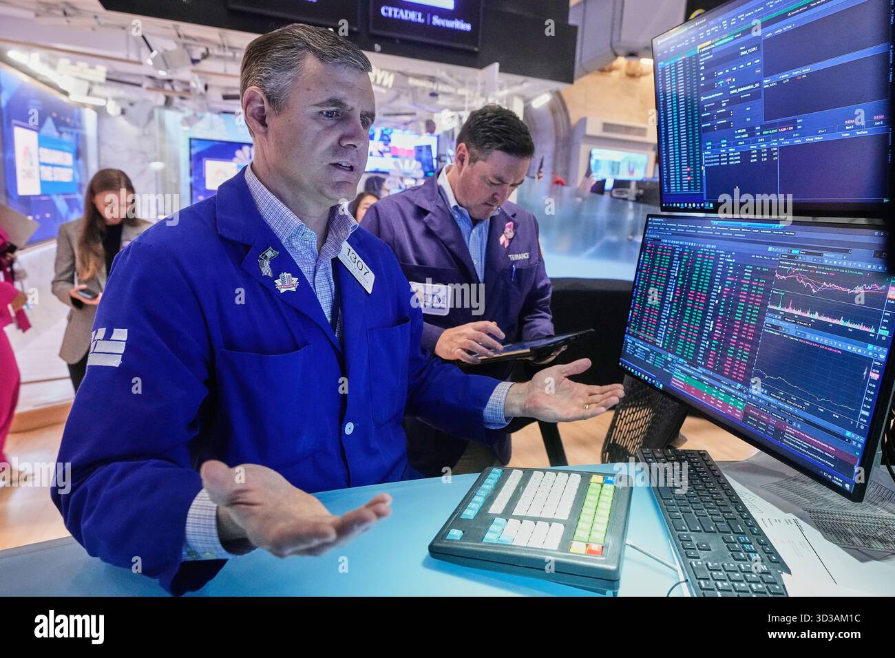 Specialist Thomas Schreck, foreground, works at his post on the floor ...