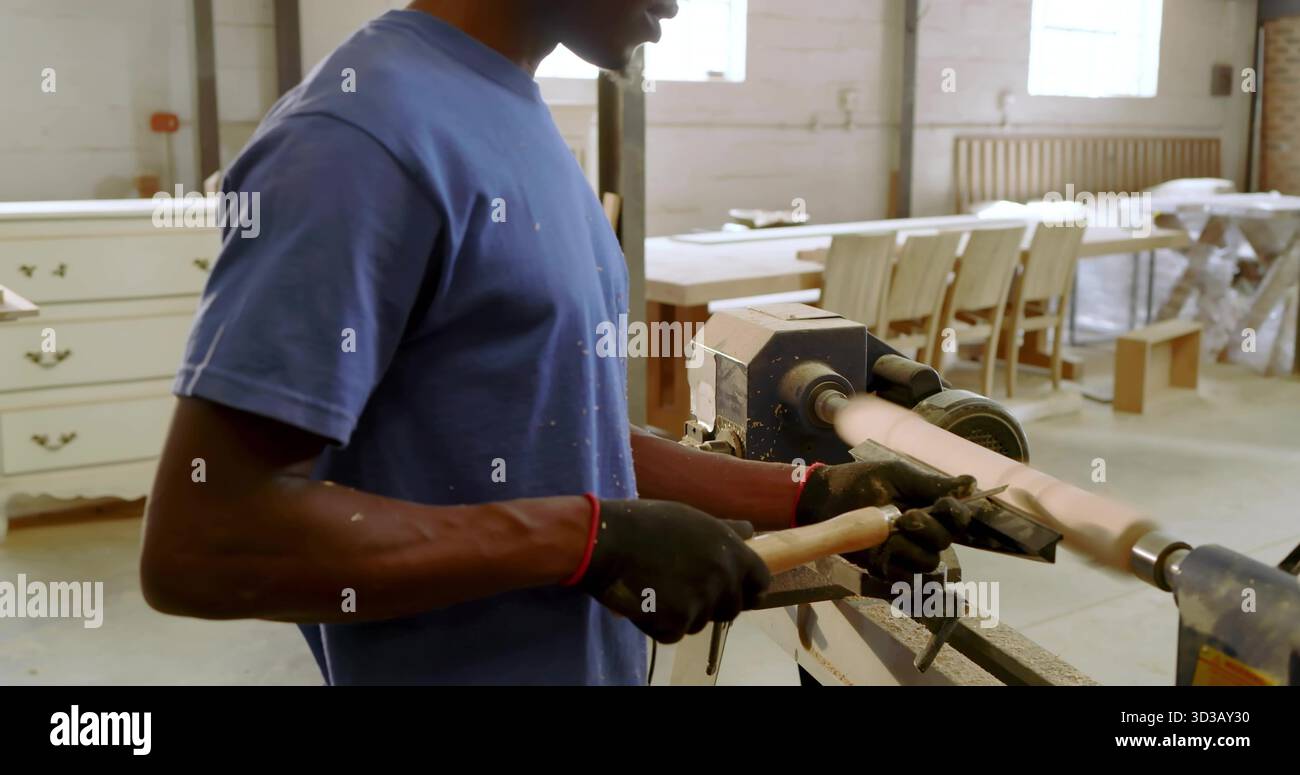 Turning mid adult man shaping spindle with chisel on wood lathe in ...