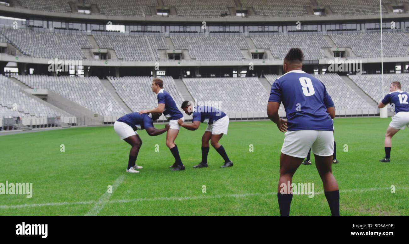 Forming seven male athletes practicing scrum in empty stadium, with ...