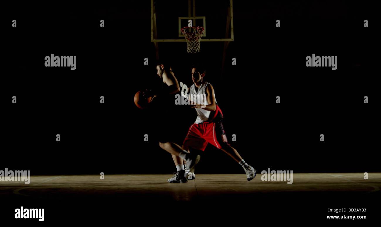 Two basketball players wearing jerseys jumping under hoop at gym free ...