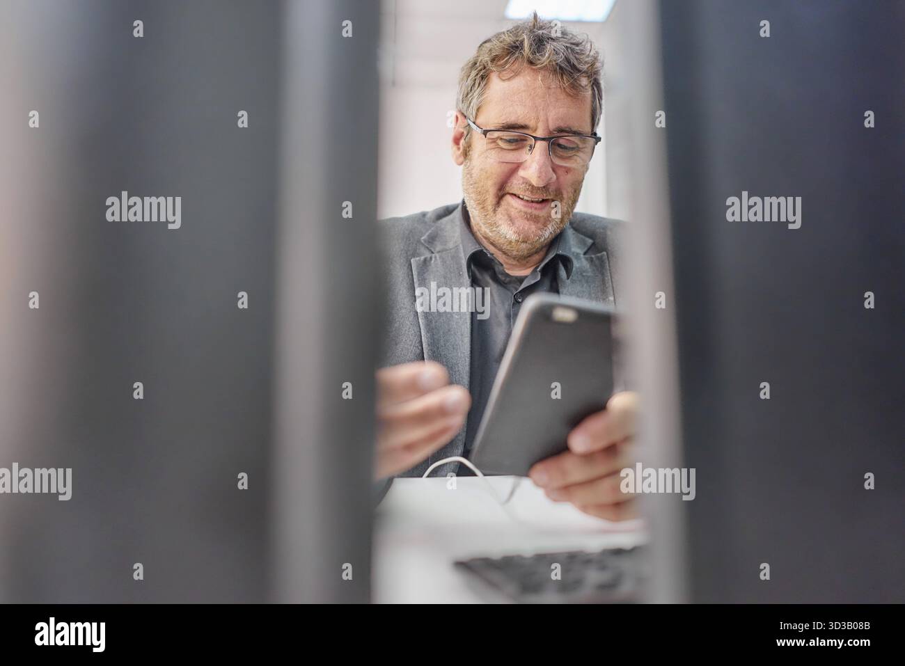 Senior business man being entertained at work laughing between two ...