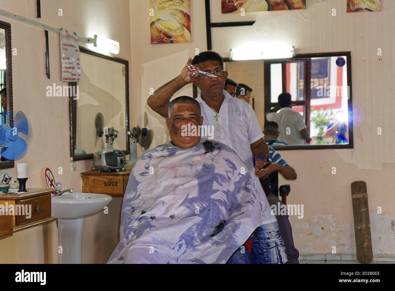 Baracoa, Cuba, Central America, A man gets a haircut in a traditional ...