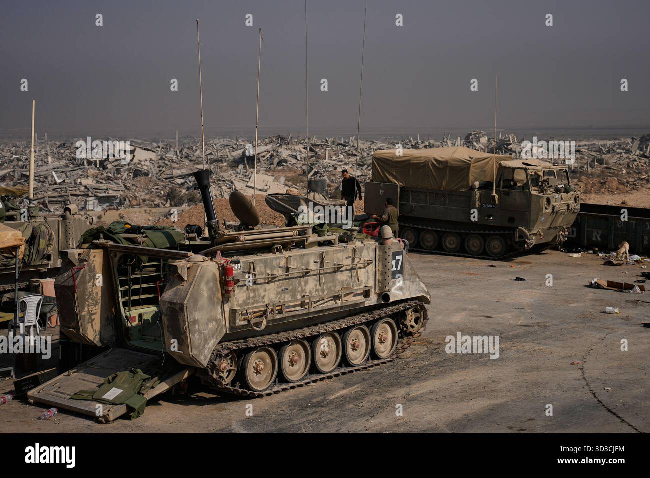 Israeli army vehicles are parked near buildings in ruins after Israeli ...
