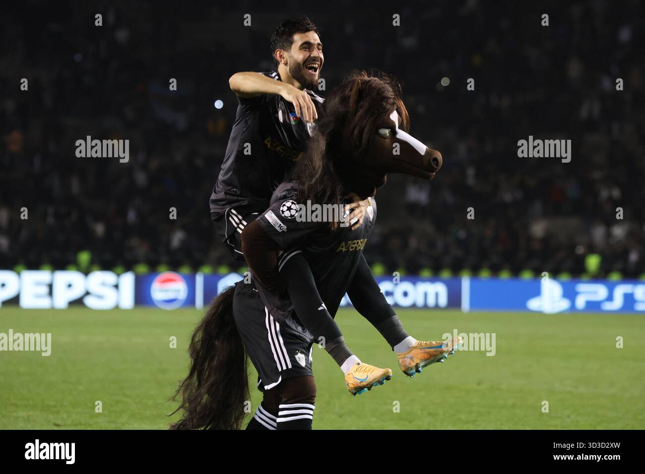 Qarabag's Elvin Jafarguliyev rides a Qarabag's maskot after the Champions League opening phase ...