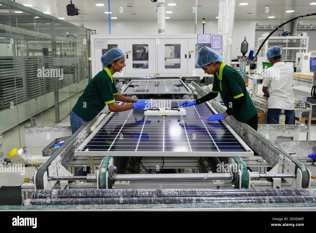 FILE - Workers put switches and connectors on solar panels after they ...