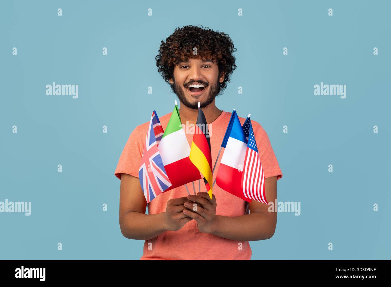 Happy Hindu Guy With Diverse Flags in Blue Studio Background Promoting ...