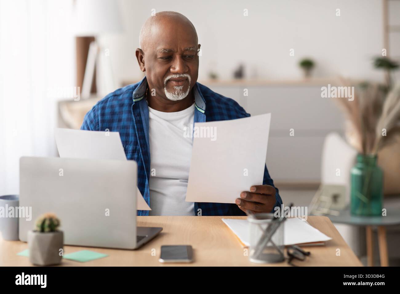 Mature Black Businessman Reviews Bills and Documents at Modern Office ...