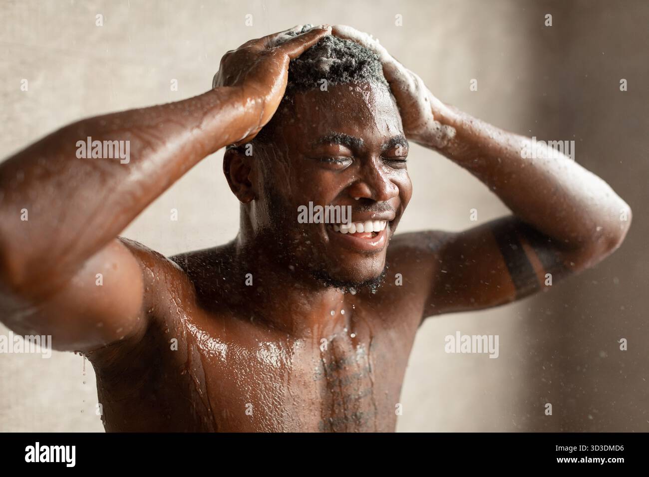 African Guy Enjoying a Refreshing Shower While Washing His Hair With ...