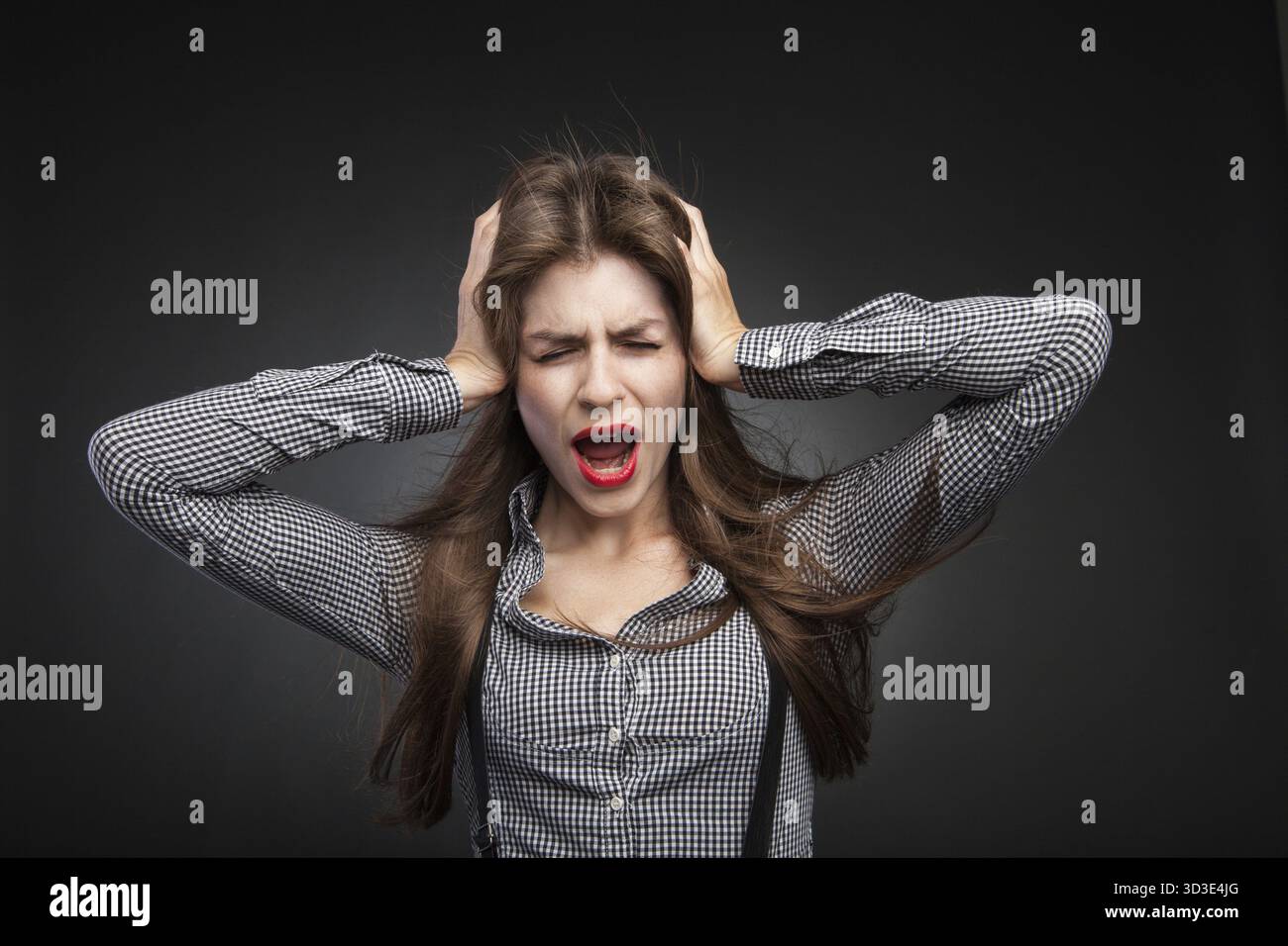 Painful headache. Woman screaming with her ears closed with her arms ...