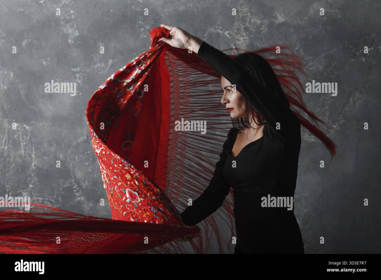 Young adult spanish woman dancing flamenco on gray vintage studio ...