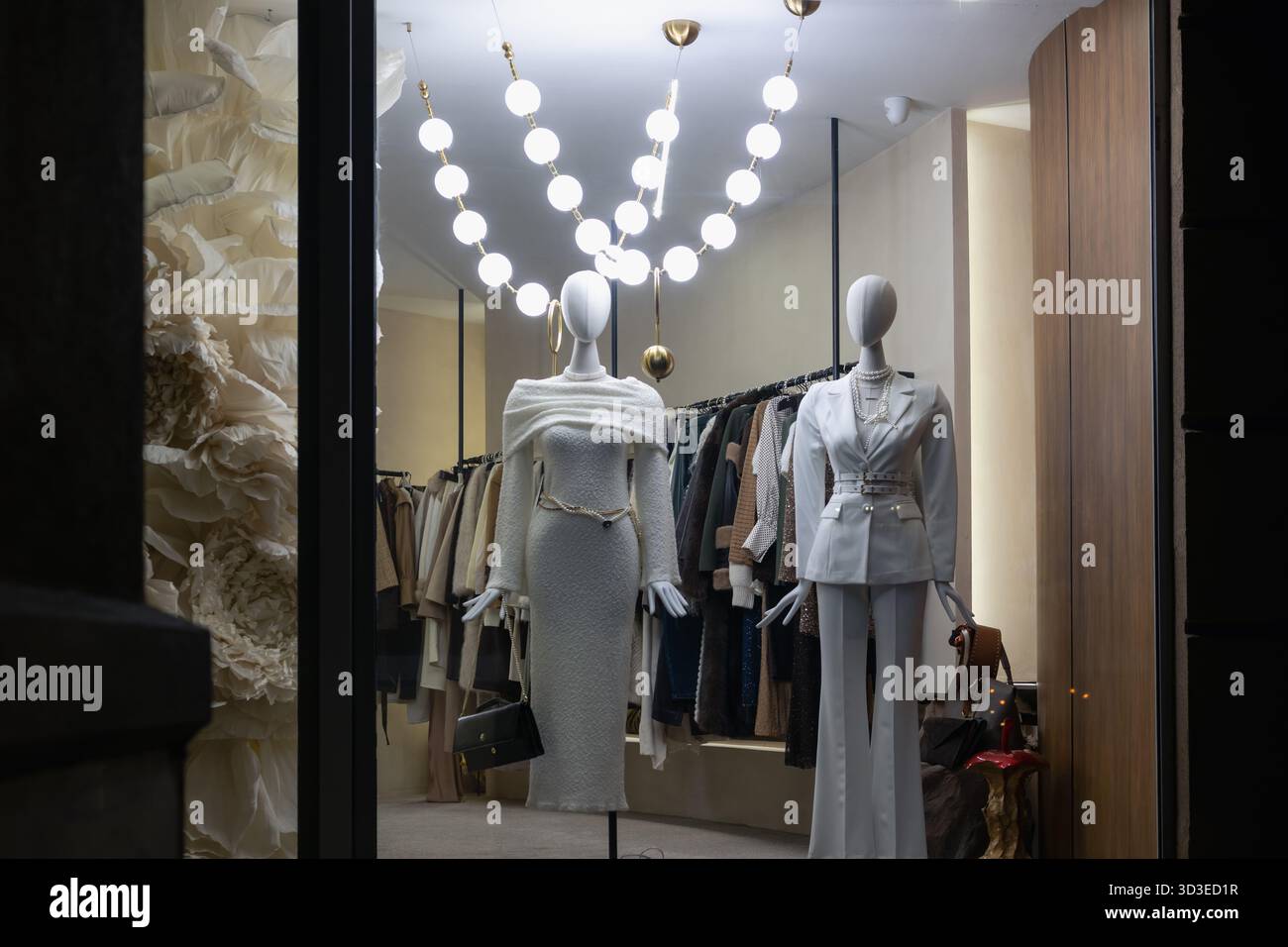 luxury fashion boutique window display at night with two mannequins ...