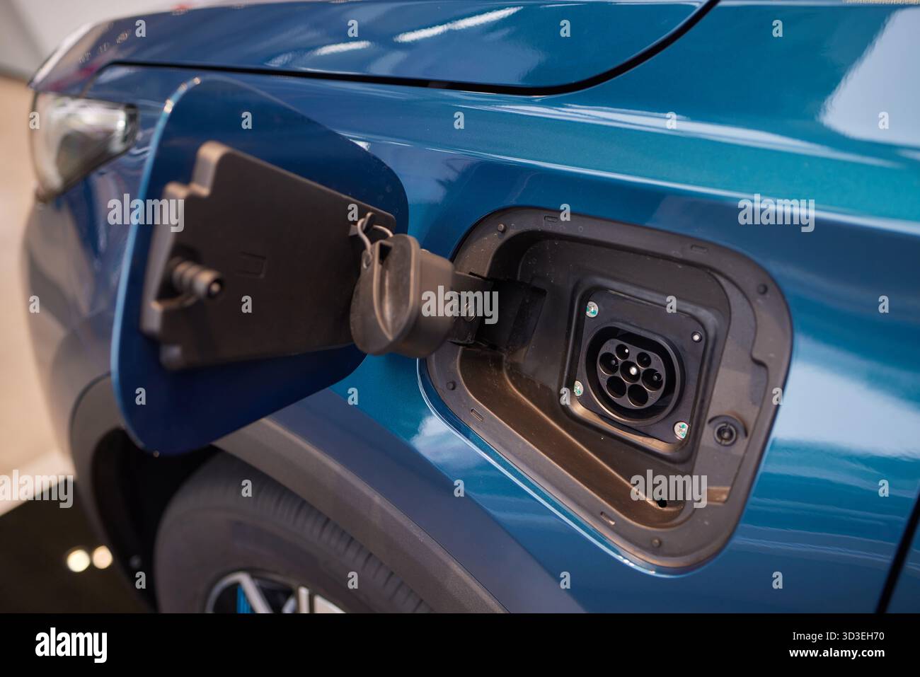 Unrecognizable businessman plugging electric car from charging station ...