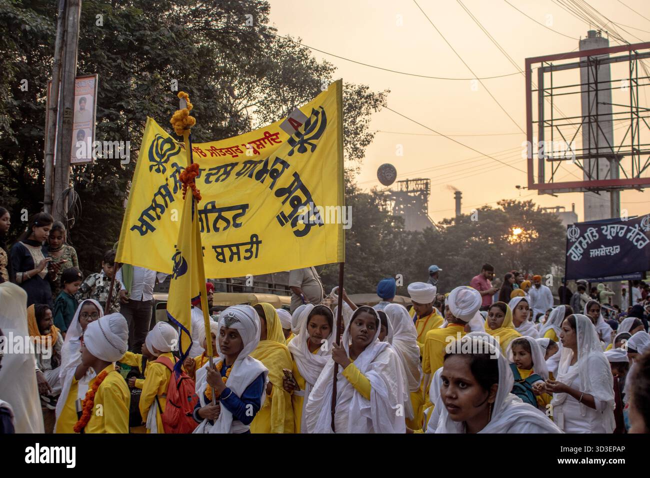 A group of Sikh children in traditional attire walk along a street with ...