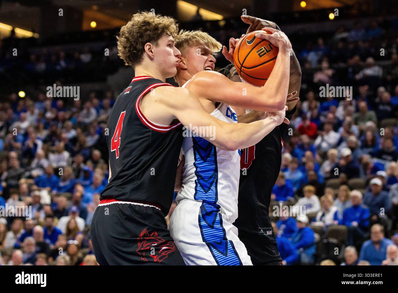Creighton guard Ty Davis, center, and South Dakota guard Vince Buzelis ...