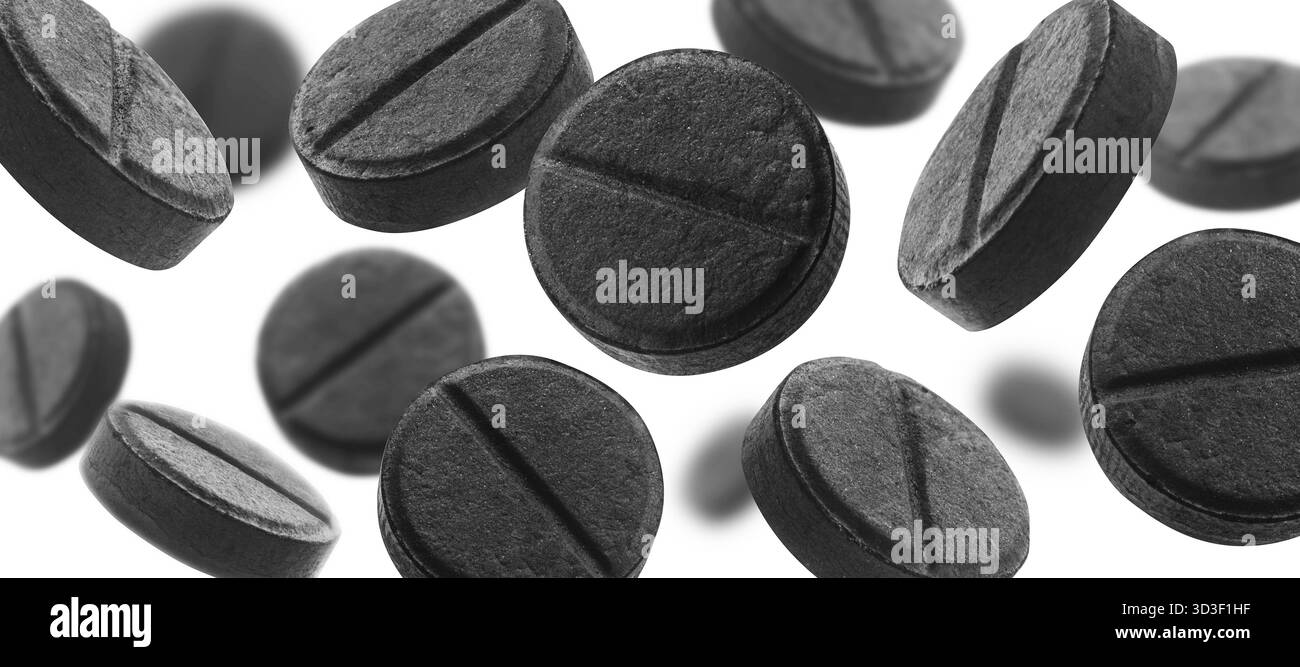 Black activated carbon tablets levitate on a white background Stock ...