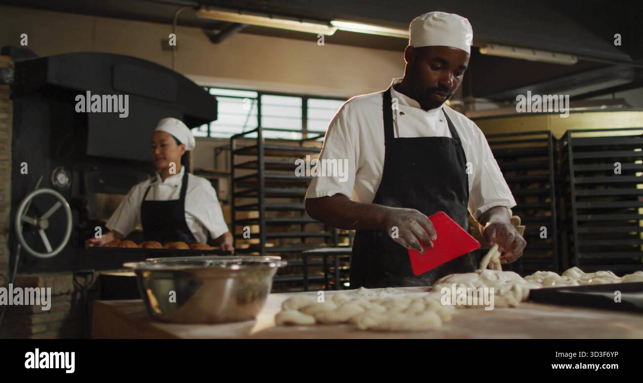 Shaping braided loaves baker wearing chef uniform at bakery kitchen ...