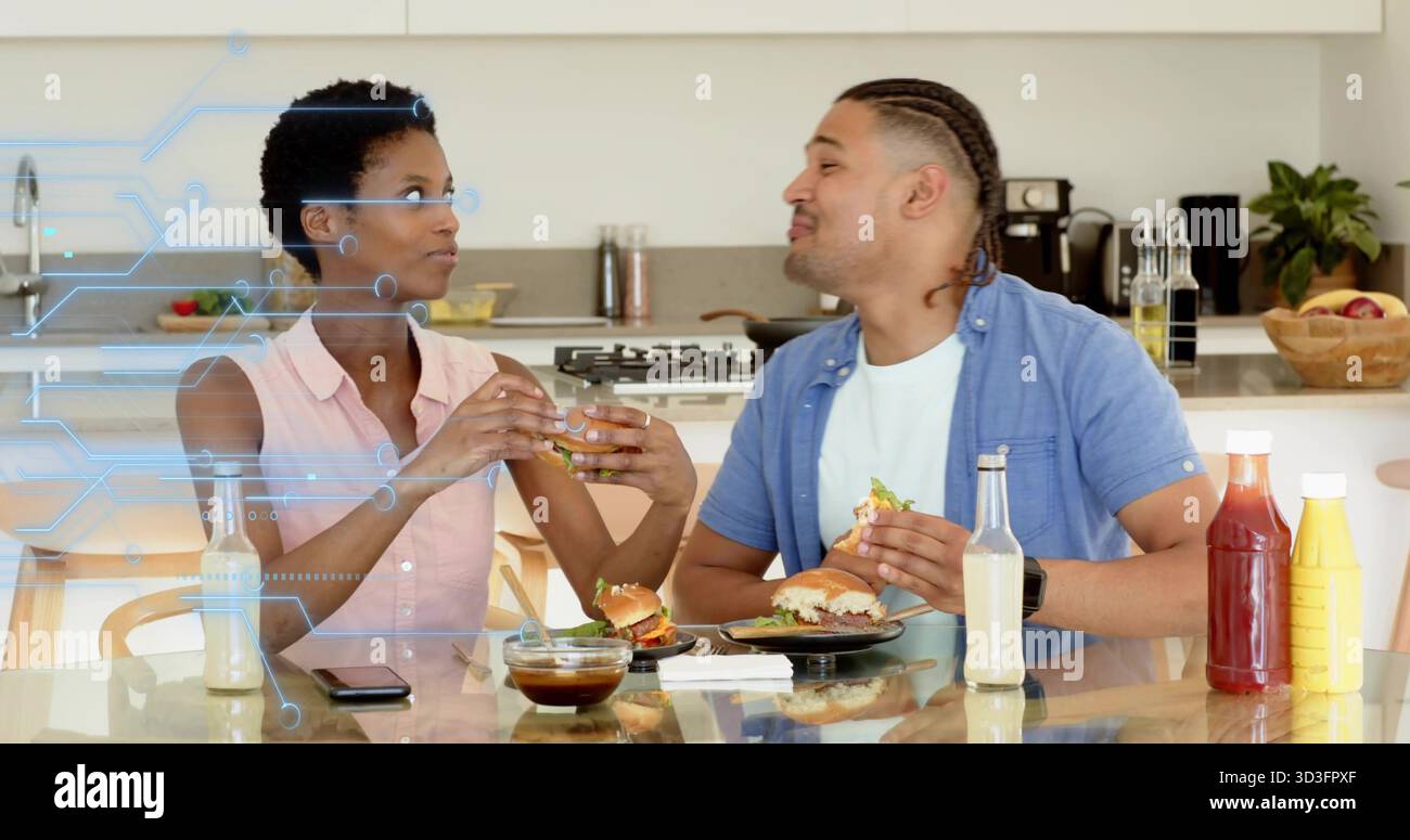 Chatting couple sitting at glass-top dining table in modern kitchen ...