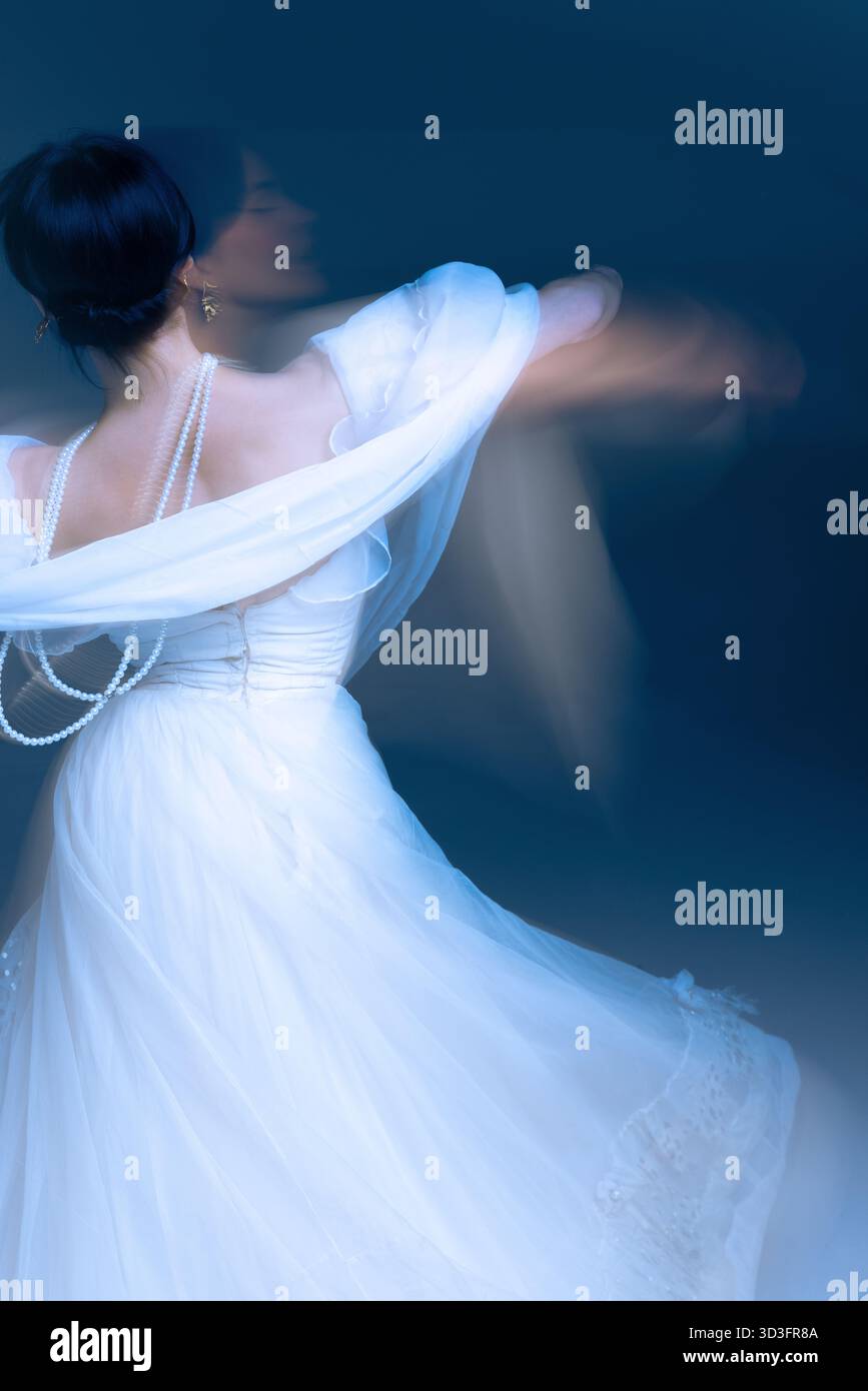 Dancer back in soft blue light, pearls tracing fluid choreography lines ...