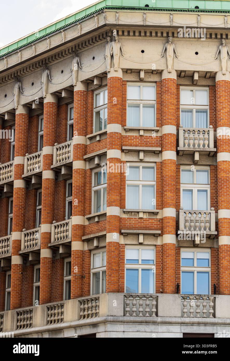 corner building with striped brickwork and green roof Stock Photo - Alamy
