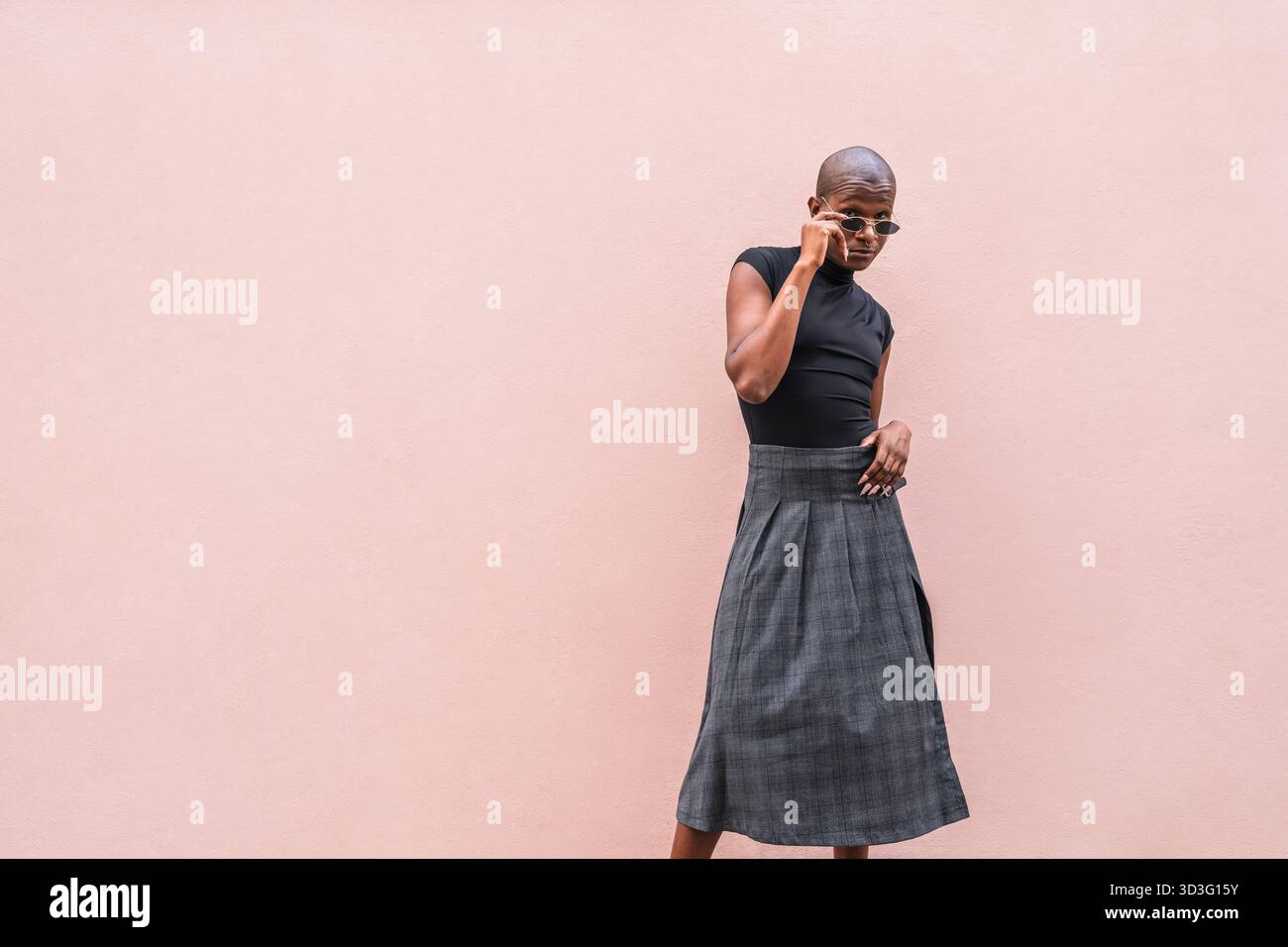A young LGBTQ man confidently poses in a modern outfit, embracing ...
