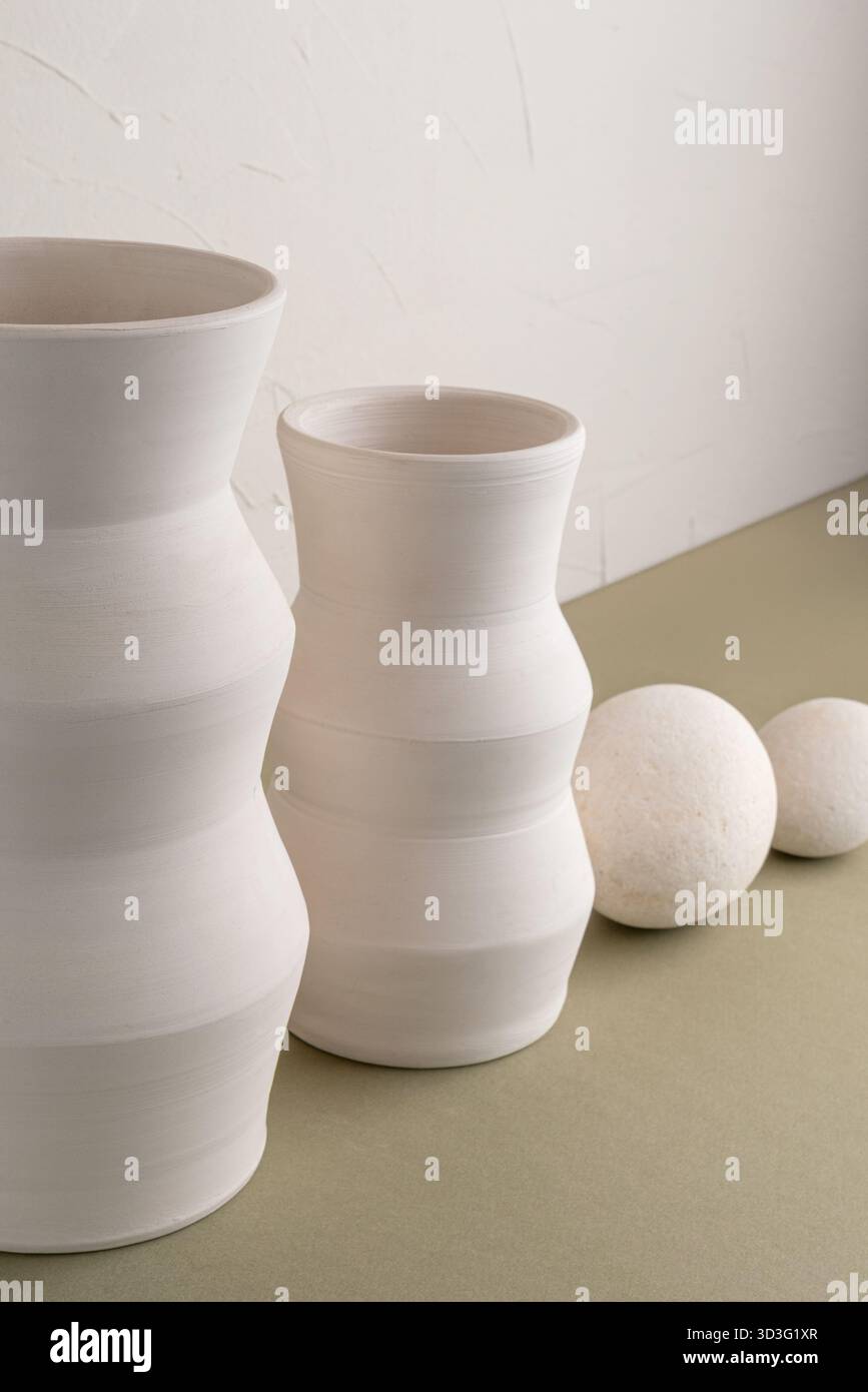 Minimalist white ceramic vases with smooth curves are elegantly ...
