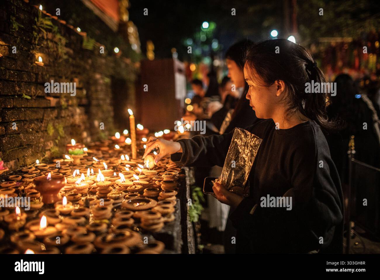 People light candles at Wat Lok Moli during Yi Peng (Yee Peng) Festival ...