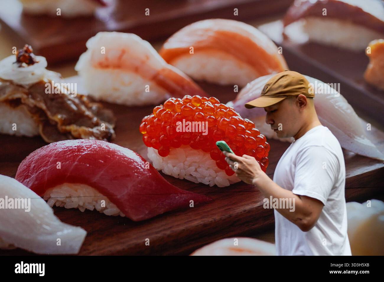 A man walks pass a poster for sushi on November 6, 2025 in Hong Kong ...