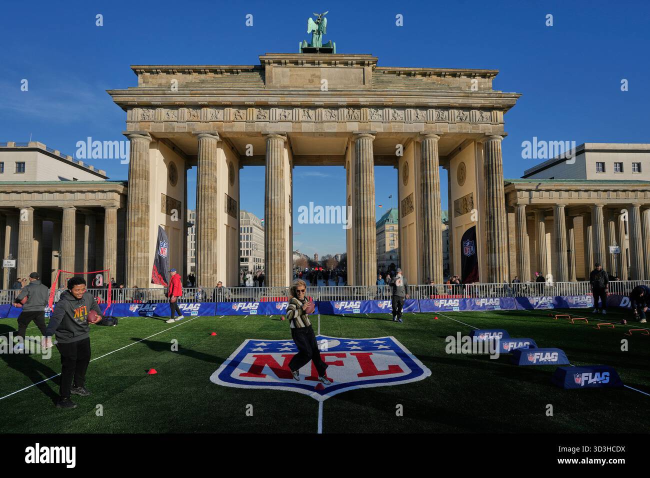 A woman practices at the NFL Experience event in front of the ...