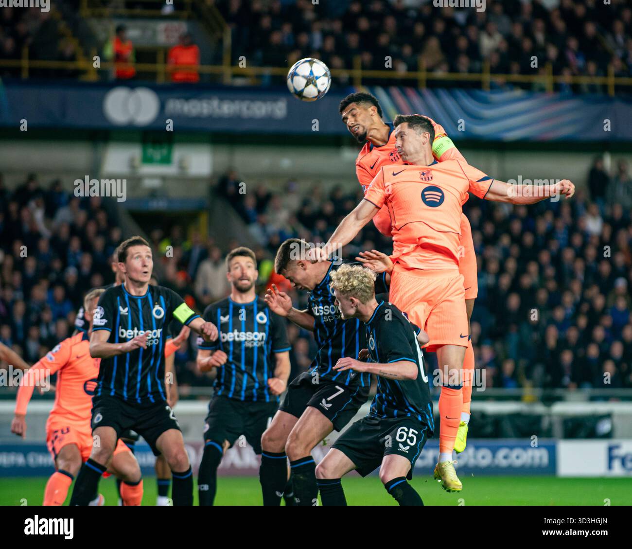 Robert Lewandowski of Barcelona heads the ball with Ronald Araújo of ...