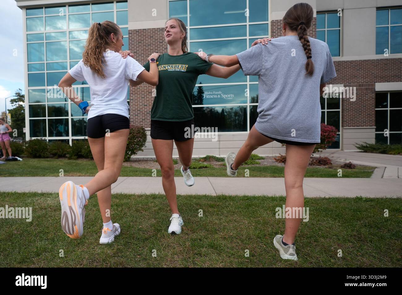 Cross country runner Madison DeCleene warms up with her St. Norbert ...