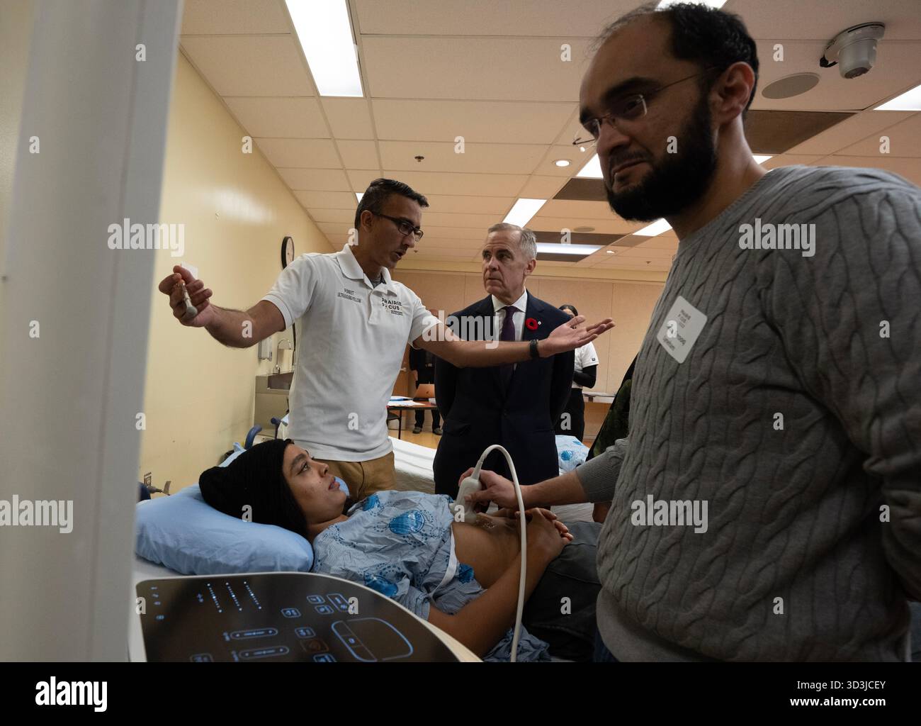Prime Minister Mark Carney listens to a doctor as he tours the Ottawa ...