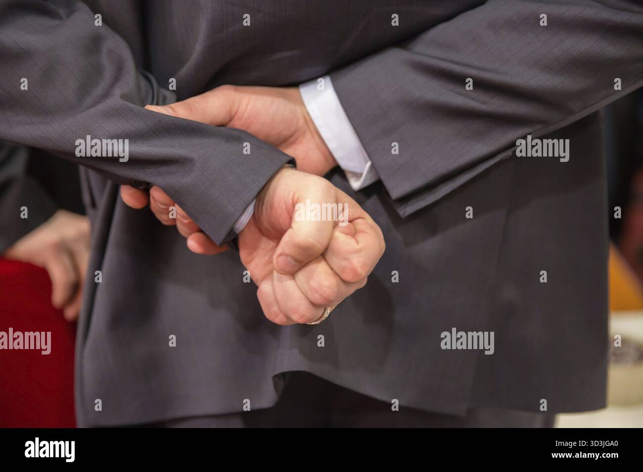Businessman hiding his fist in the back Stock Photo - Alamy