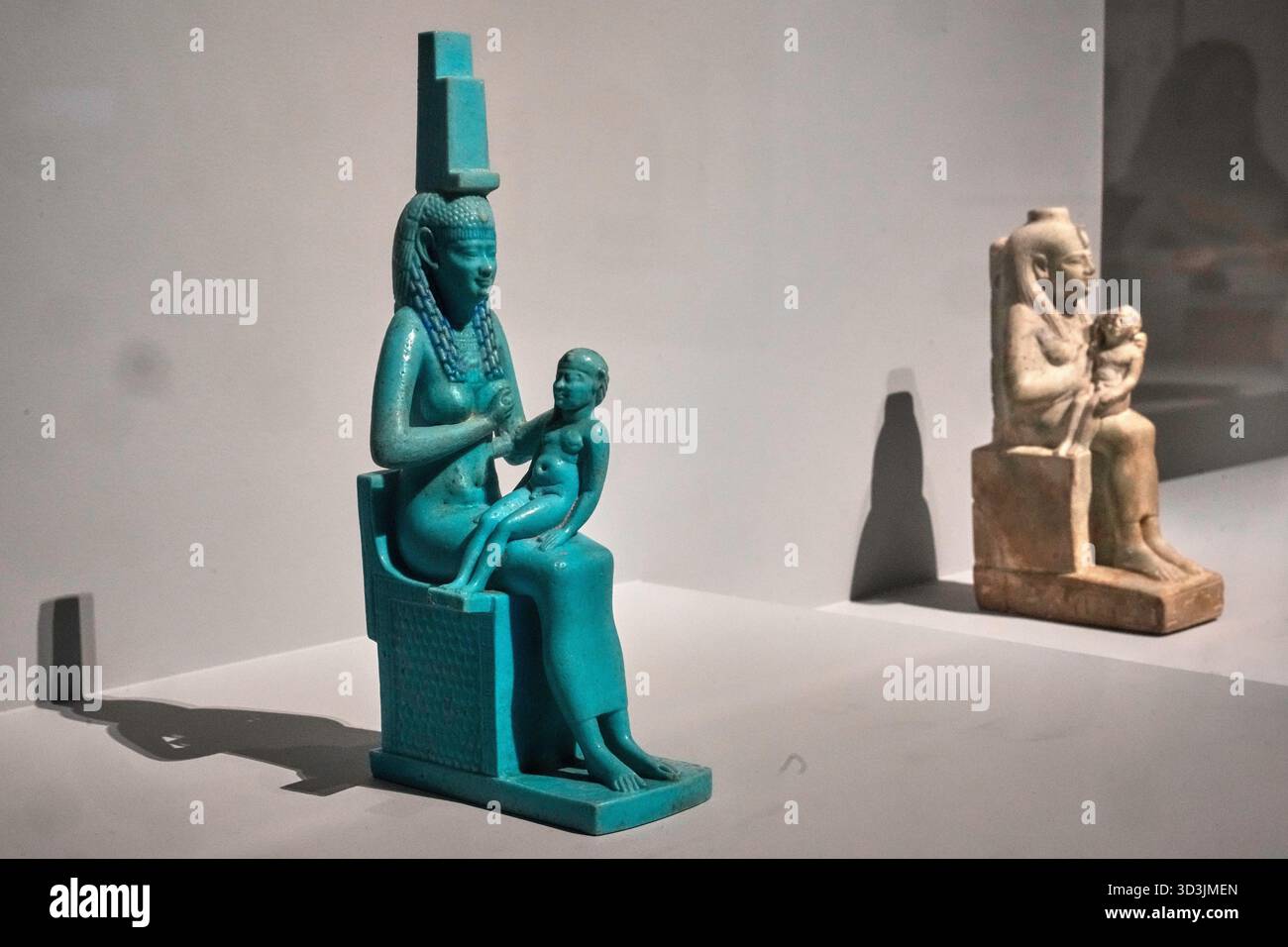 A statuette of Isis with the infant Horus, left, and an amulet of Isis ...