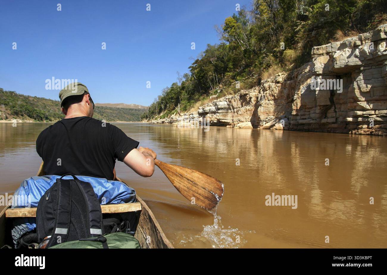 Tourist paddling small canoe on the Tsiribihina river in Madagascar ...