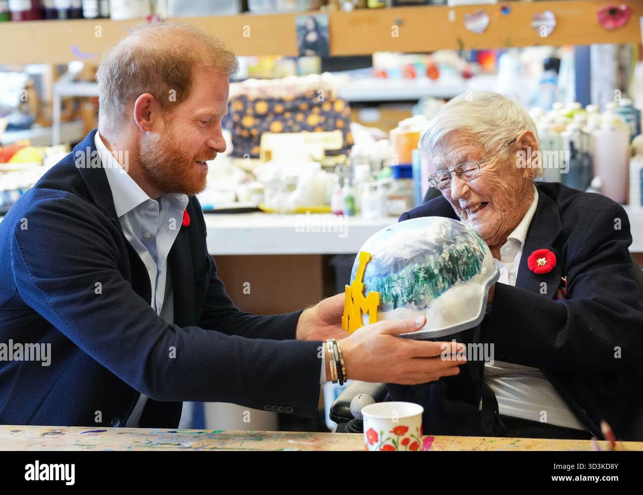Prince Harry, left, receives a painted army helmet from 101 year-old ...