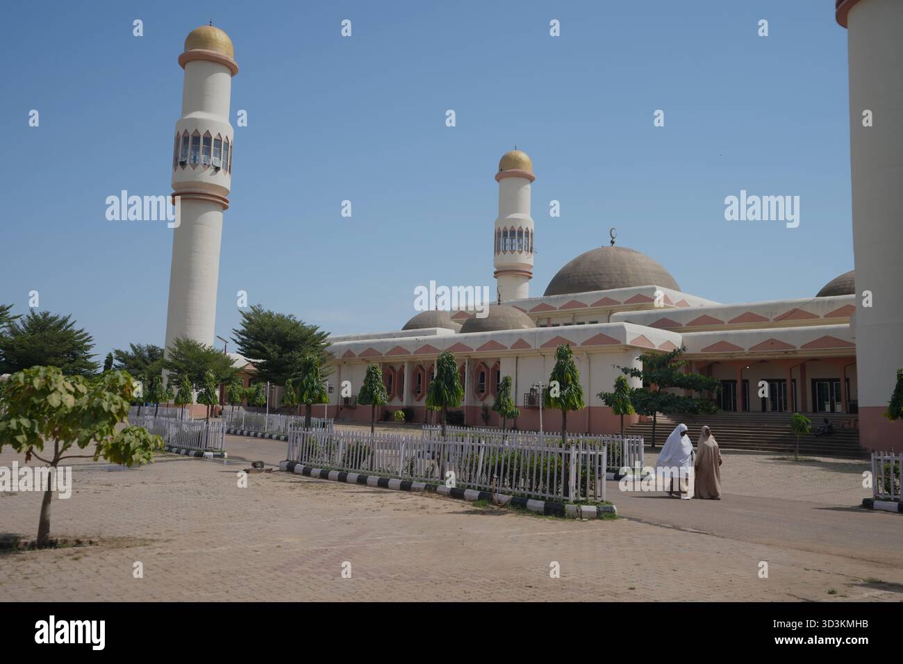 Two women walk past the Central Mosque in Kaduna, Nigeria, Thursday ...