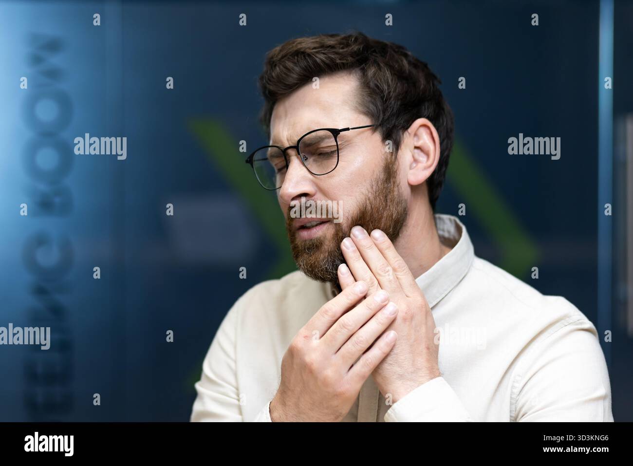 Close-up photo of a young man working in an office and holding his ...