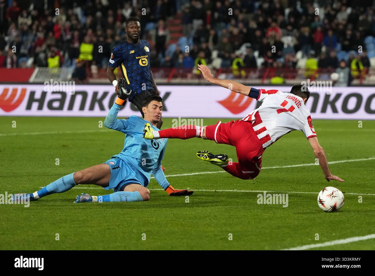 Lille's goalkeeper Berke Ozer fouls Red Star's Mirko Ivanic in the box ...