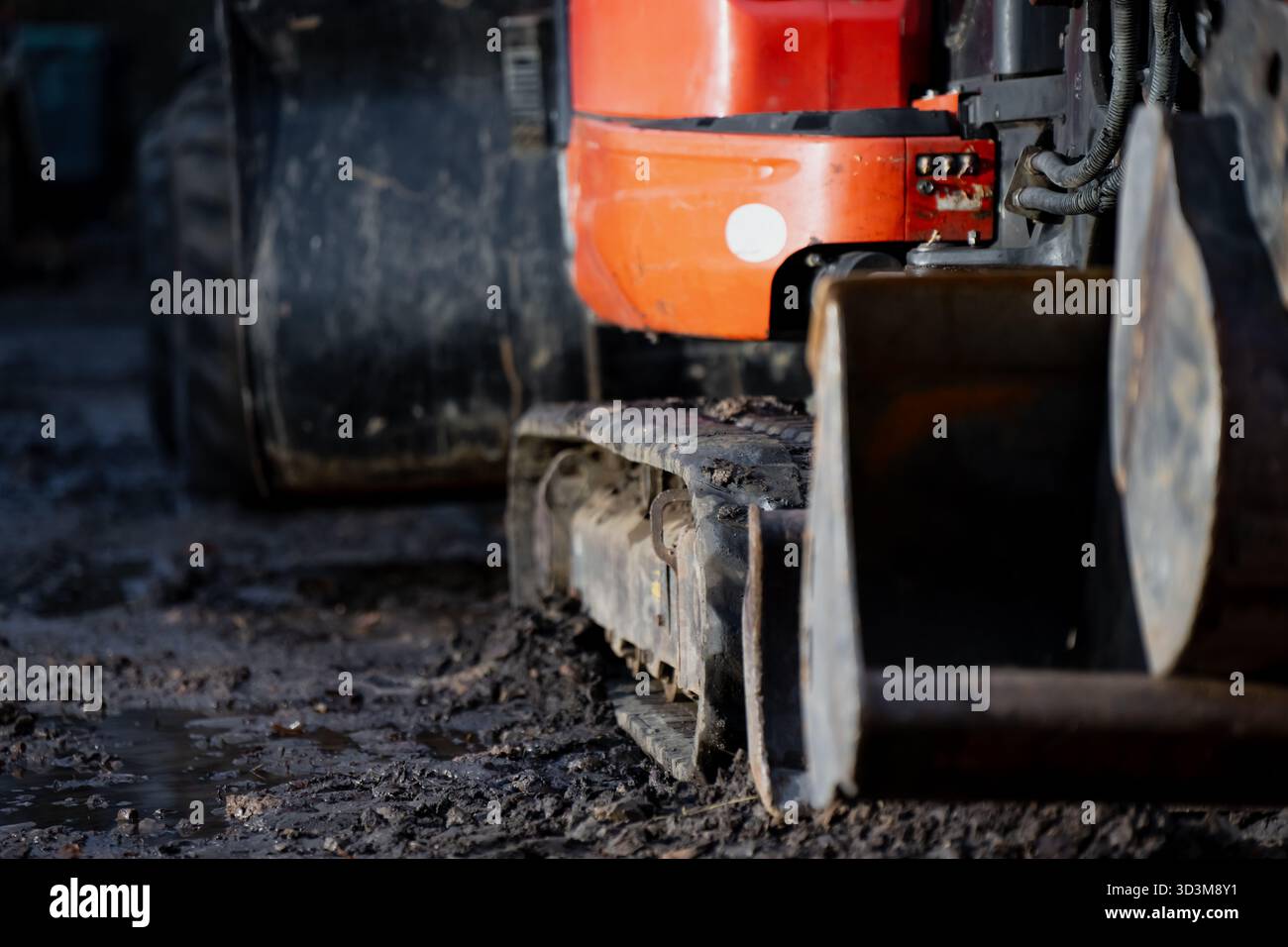 Industrial construction machine with crawler tracks and bucket on muddy ...
