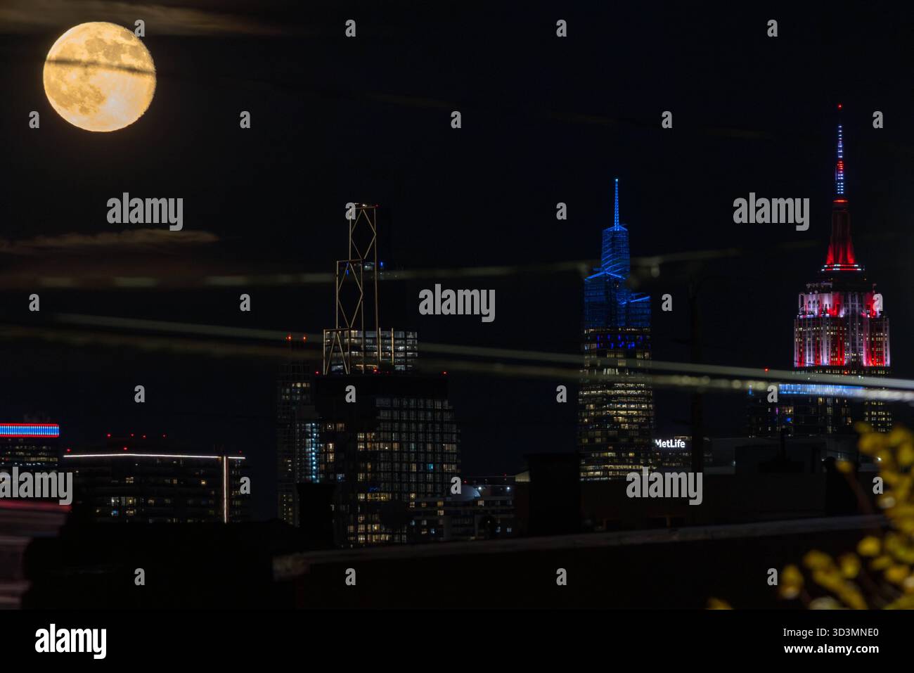 A full moon is seen next to the Empire State Building on Manhattan ...
