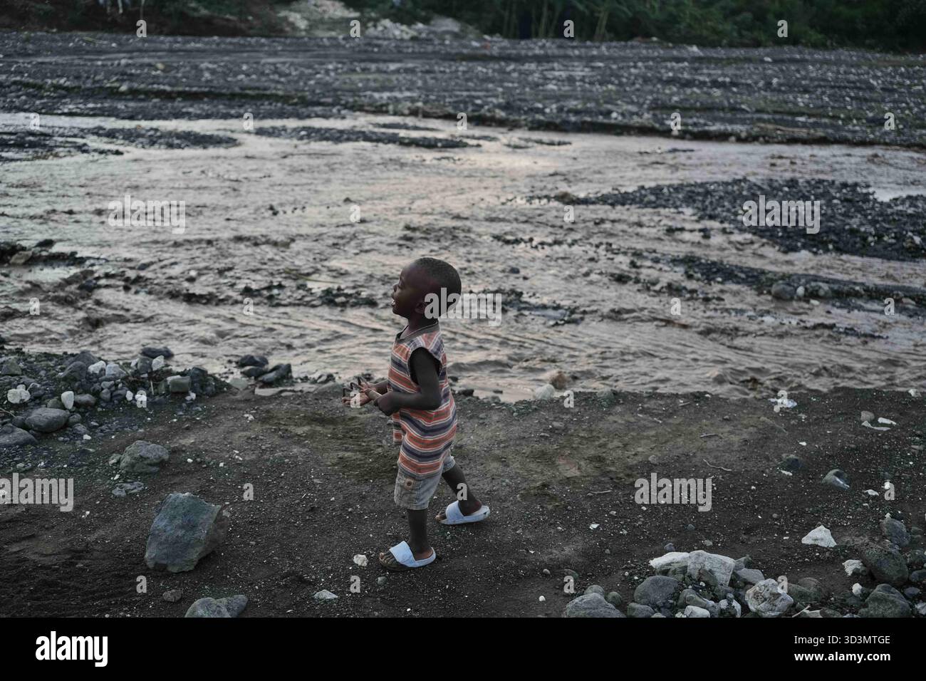 A child walks on the banks of La Digue River in the aftermath of ...