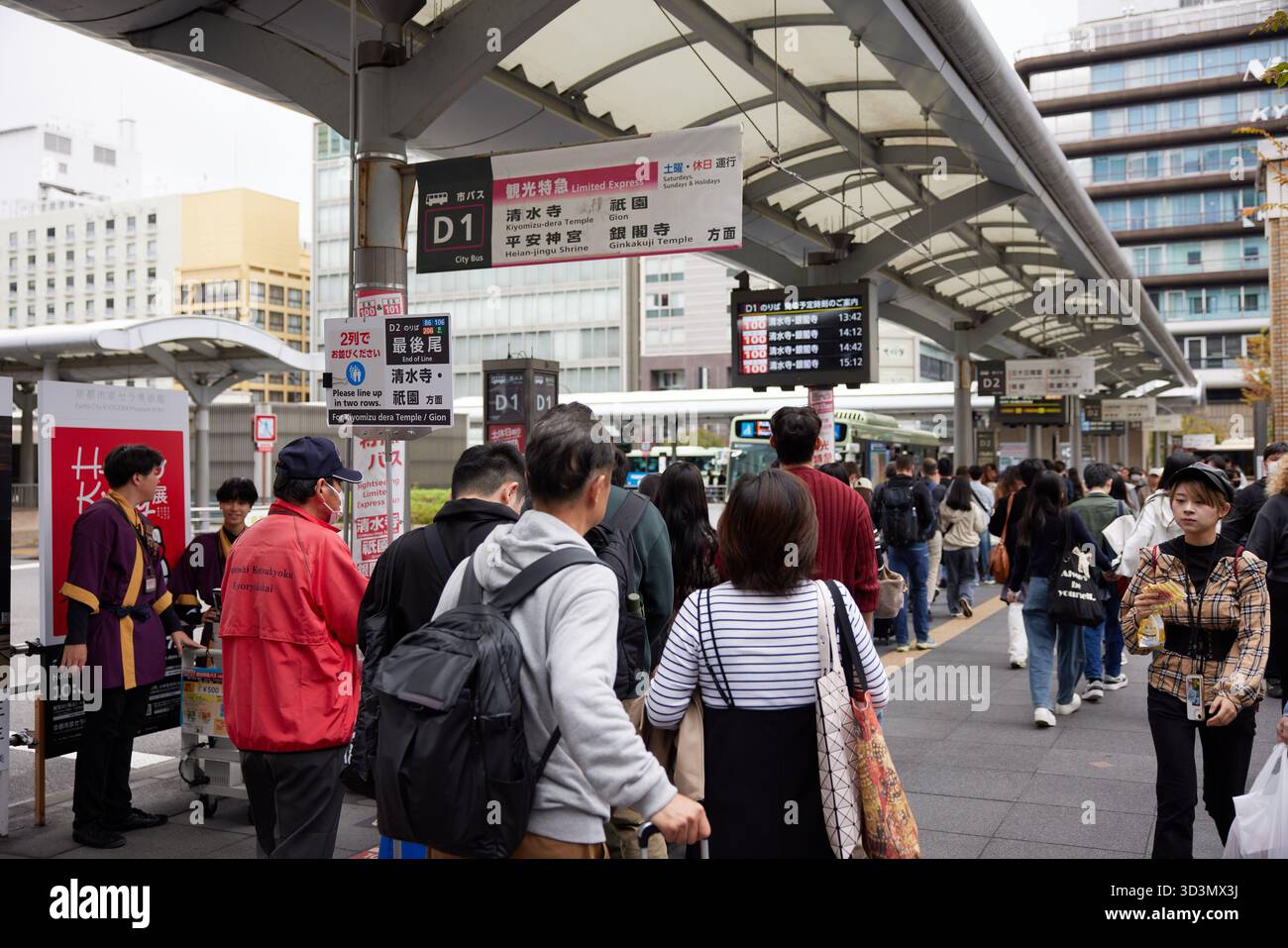 Many tourists line up at the Kyoto Station Bus Terminal in Kyoto, Japan ...